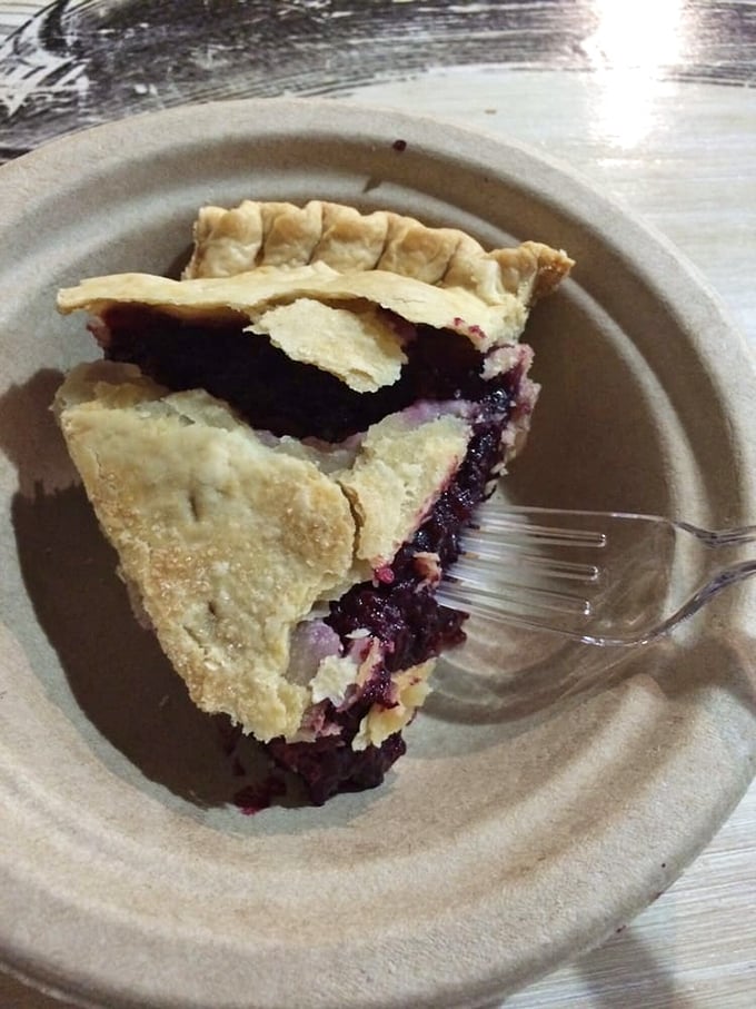 Berry perfection on a plate – this slice of marionberry pie showcases Oregon's purple gold nestled in a flaky, buttery crust that shatters just right.
