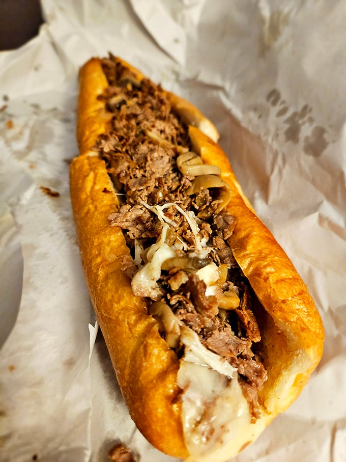 Behold the mushroom cheesesteak in its natural habitat: tender beef nestled under a blanket of melted cheese and sautéed mushrooms. Poetry on a roll.