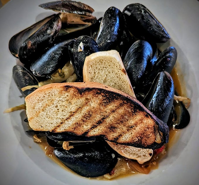 These aren't just mussels; they're little black shells of joy swimming in a broth so good you'll consider drinking it like soup when no one's looking.