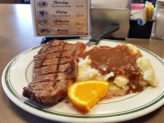 Behold the star attraction: a perfectly grilled New York steak alongside gravy-laden mashed potatoes. This isn't just dinner—it's edible therapy after a long day.
