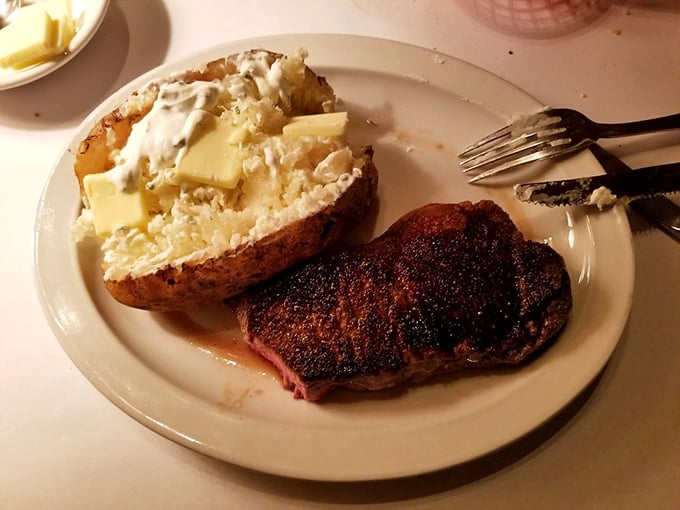 This isn't just a steak; it's a declaration of independence from food fads – a perfectly seared New York strip with a loaded baked potato that screams "America!"