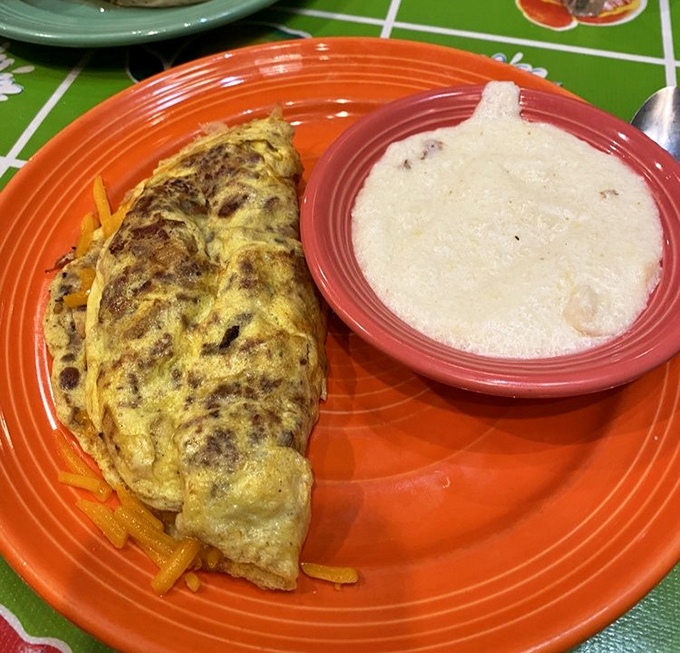 That perfect fold, that golden exterior—this isn't just an omelet, it's breakfast architecture with a side of creamy grits for good measure.