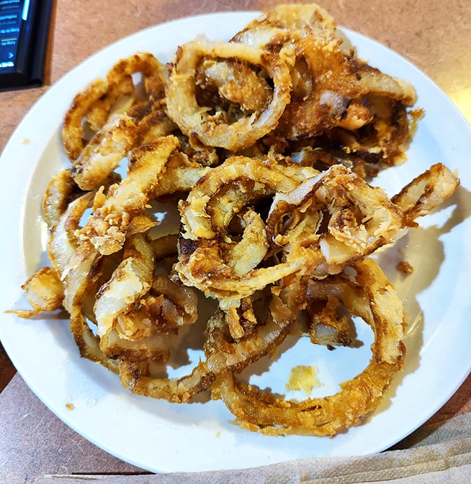Behold the stars of the show! These golden-brown onion rings aren't just fried—they're transformed into crispy halos of perfection that demand a pilgrimage.