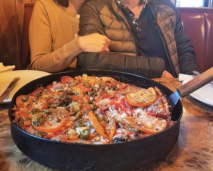 This isn't paella (despite our misleading title), but a glorious pan pizza loaded with enough toppings to make a Spaniard nod in respect.