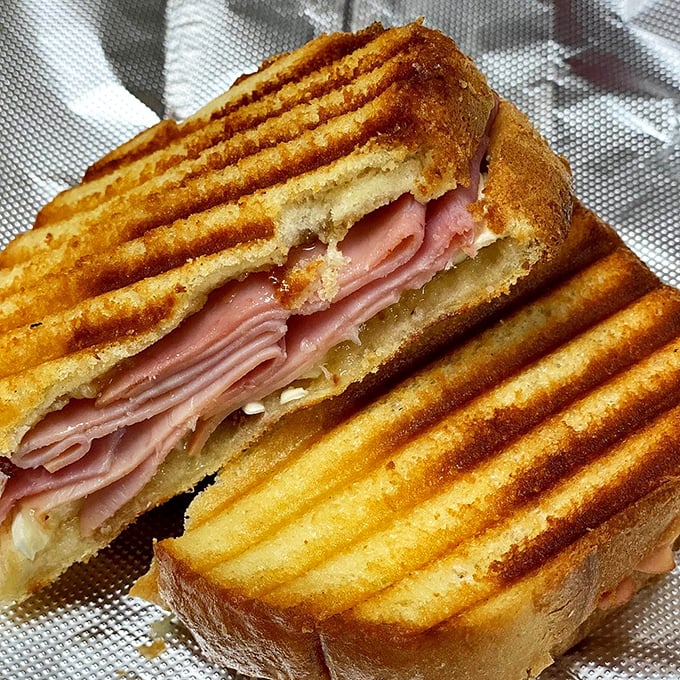 This isn't just a ham sandwich; it's edible architecture. Golden, perfectly pressed bread giving way to layers of savory goodness.