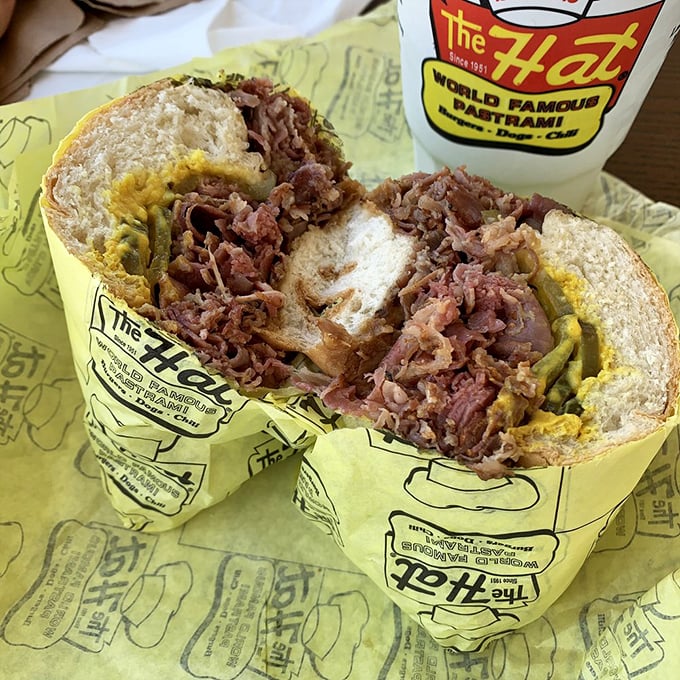 Behold the star of the show—paper-thin pastrami piled impossibly high on a soft roll with just enough mustard to cut through the richness.