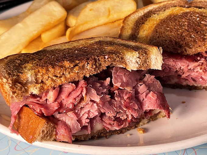 The pastrami sandwich that launched a thousand food pilgrimages—pink, peppery perfection piled high between toasted rye that barely contains its delicious cargo.