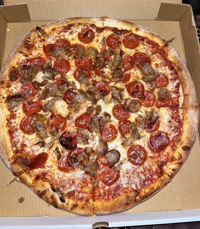 Pizza perfection doesn't need fancy toppings—just perfectly curled pepperoni cups and savory sausage on a canvas of melted cheese. This is edible art, DelCo style.