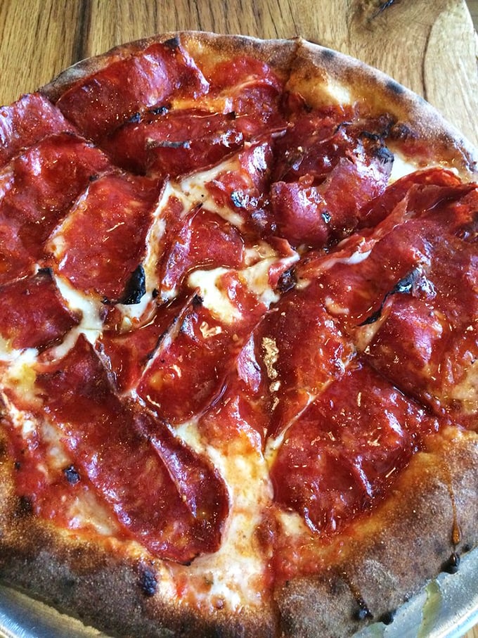 This isn't just pizza—it's a manifesto of proper Neapolitan technique. That leopard-spotted crust has the kind of char that makes pizza purists weep with joy.