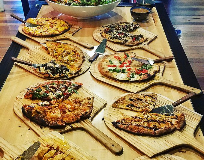 Pizza paradise on wooden paddles—each one a different journey through flavor country, with crusts that deserve their own fan club.
