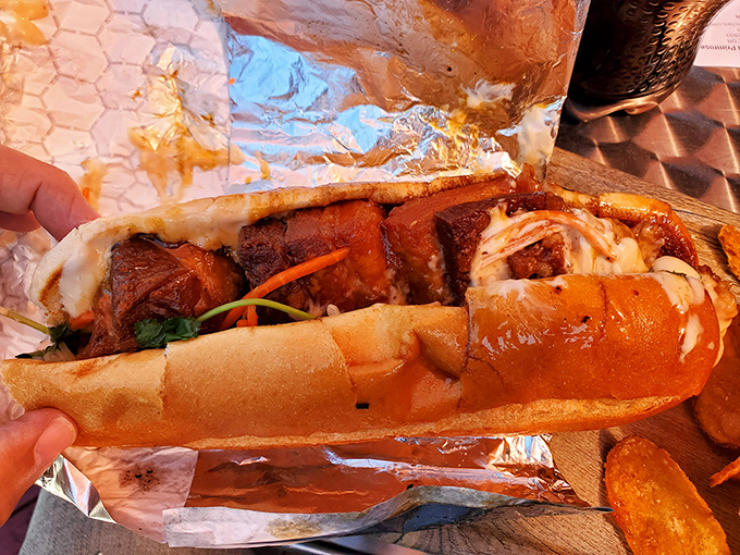 Behold the pork belly masterpiece – glistening, caramelized chunks nestled in a perfect roll. This isn't a sandwich; it's an edible work of art.