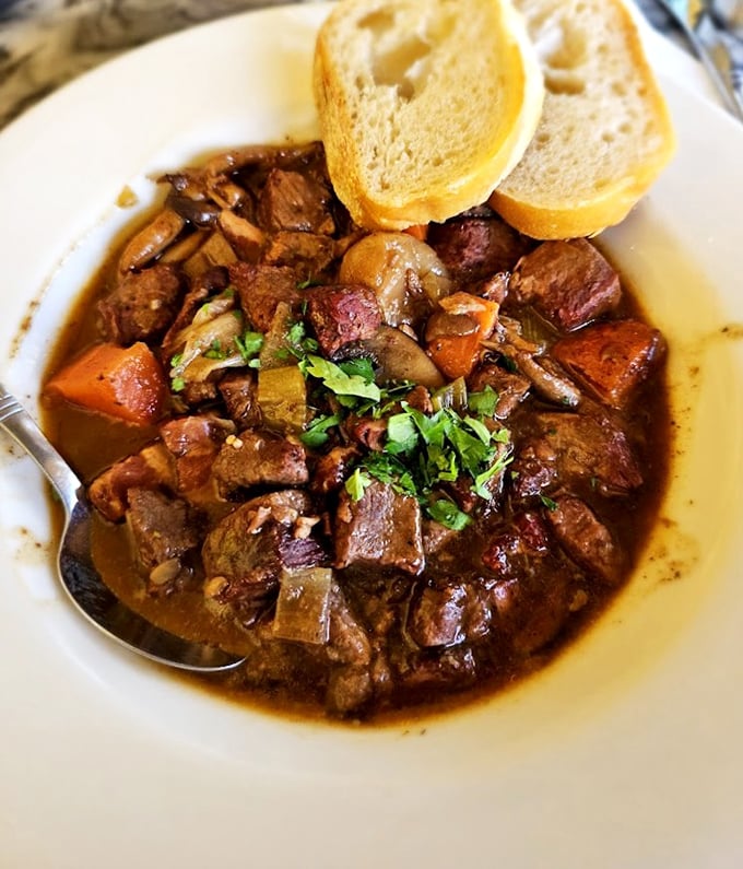 The Boeuf Bourguignon isn't just dinner—it's therapy in a bowl. Tender beef surrenders to wine-infused broth while crusty bread stands ready for sauce-sopping duty.