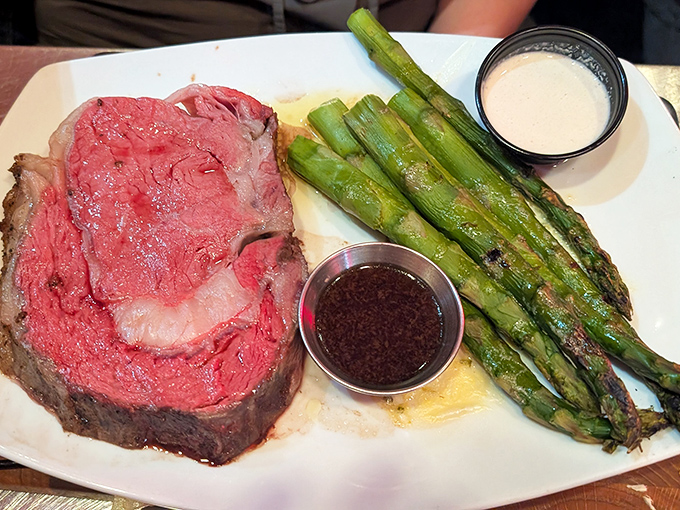 Behold the star of the show – prime rib so perfectly pink it should have its own Instagram account. Those asparagus spears aren't just sidekicks.