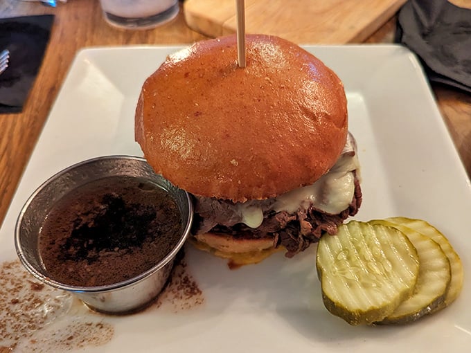 The prime rib sandwich in all its glory—tender meat, melty cheese, and that little cup of au jus waiting to elevate everything. Pickle for perspective.