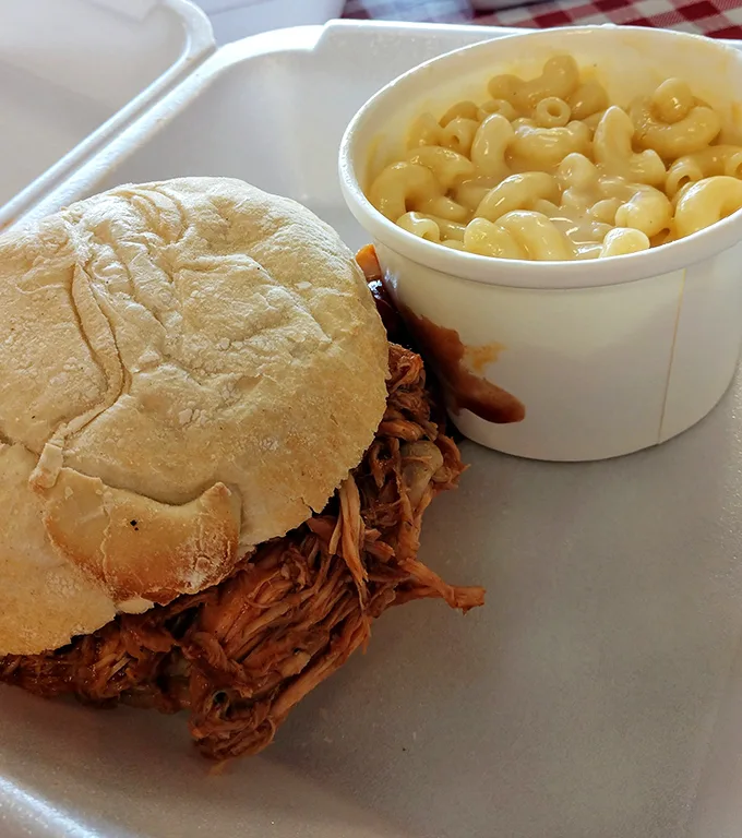 This pulled pork sandwich isn't just food – it's edible evidence that patience and smoke create magic that no microwave ever could.