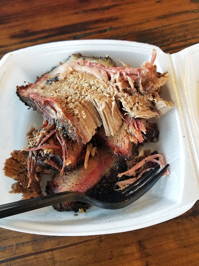 Behold the brisket in all its glory – that perfect pink smoke ring is like nature's way of saying "you're welcome."