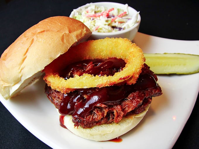 This isn't just a pulled pork sandwich—it's a barbecue masterpiece with slow-cooked meat, tangy sauce, and a crispy onion ring that'll make your taste buds do a victory dance.