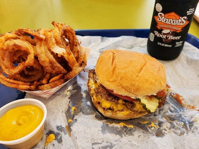 This isn't just a burger – it's a masterpiece of melted cheese cascading over multiple patties, with onion rings standing guard like crispy sentinels.