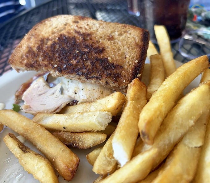 This sandwich isn't just lunch—it's therapy between bread. Golden fries standing at attention like they know they're part of something special.