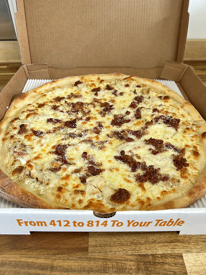 The legendary Reuben Pizza in its natural habitat—an open box. Corned beef scattered across melted cheese creates a landscape of deliciousness worth crossing state lines for.