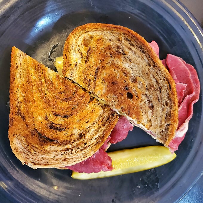 This isn't just a sandwich—it's architecture. Perfectly toasted rye, melted cheese, and that pickle standing guard like a sentry.