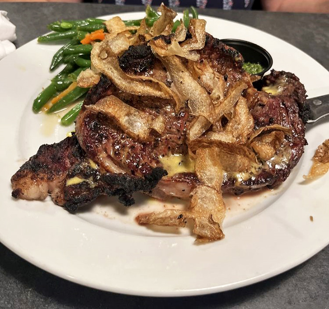 This isn't just a steak—it's a religious experience with crispy onion straws. The kind that makes you close your eyes and forget table manners exist.