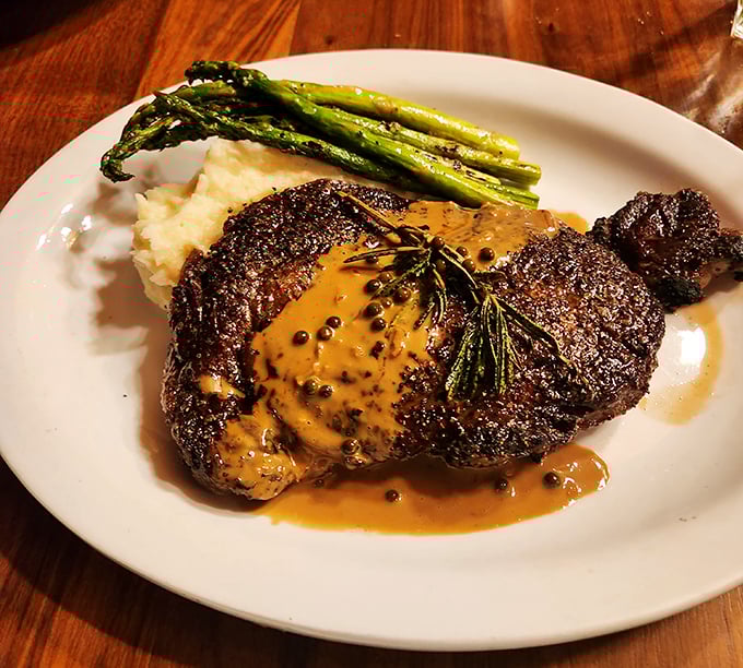 Behold the star of the show! This perfectly seared ribeye with mashed potatoes and asparagus isn't just dinner – it's a religious experience with gravy.