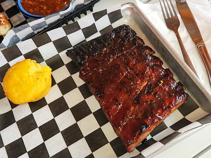 These ribs don't just fall off the bone—they practically leap onto your fork, their mahogany glaze glistening like edible stained glass.