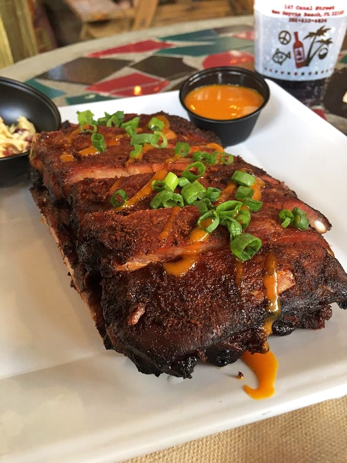 Behold the star of the show: ribs with that perfect bark, kissed by smoke and drizzled with their famous "Gold" sauce. The green onion garnish isn't just pretty—it's necessary balance.
