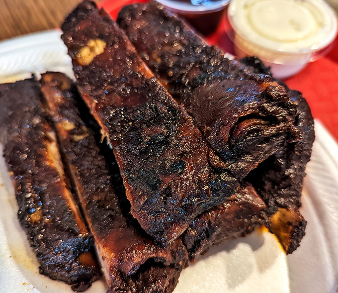 These ribs don't just fall off the bone—they practically leap into your mouth with a smoky bark that would make a lumberjack weep with joy.