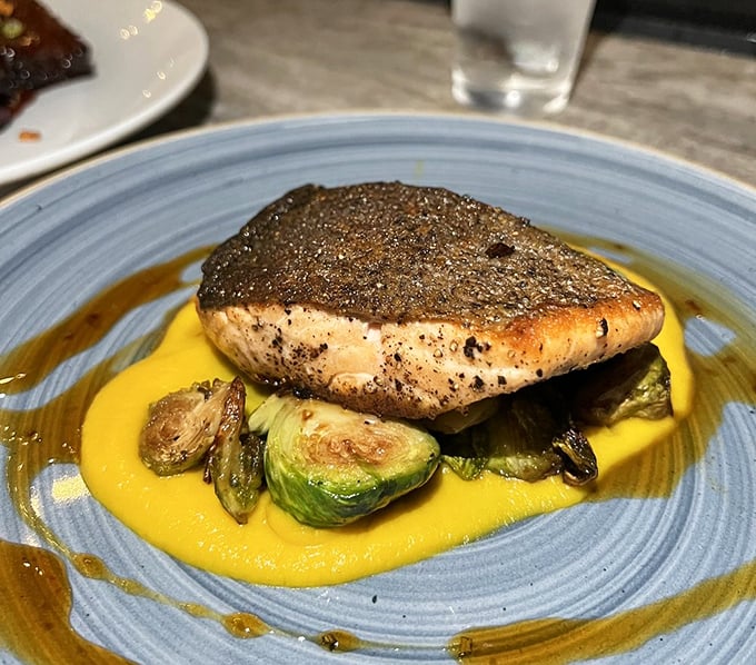 Perfectly seared salmon resting on a golden pool of sauce with charred Brussels sprouts. The fish didn't travel as far as the ship, but its journey was worth it.