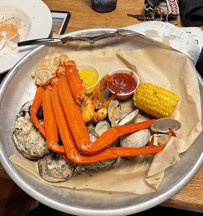 Seafood heaven on a metal tray—snow crab legs, oysters, and clams with corn on the cob. Neptune himself would approve.