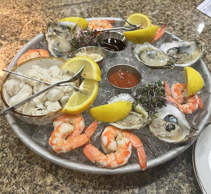 The seafood tower arrives like Neptune's personal calling card—oysters, shrimp, and crab nestled on ice with lemon wedges standing by for duty.