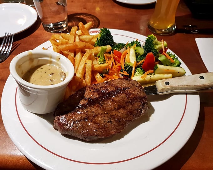 This perfectly seared sirloin arrives like a work of art—accompanied by golden fries, vibrant vegetables, and a sauce that deserves its own fan club.