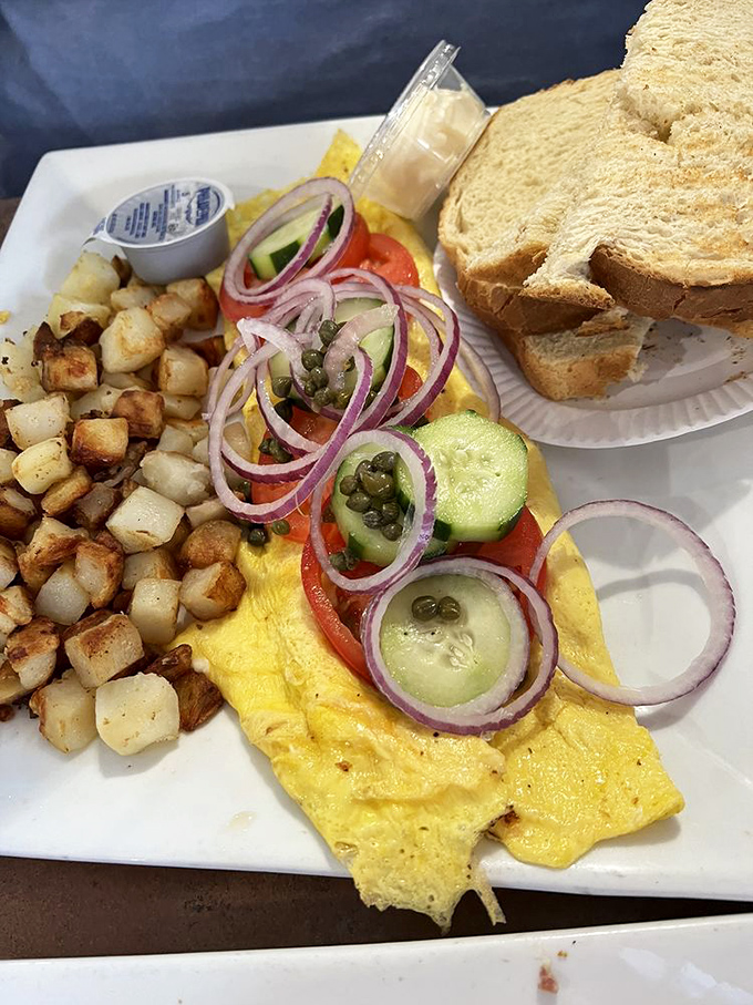 This isn't just an omelet—it's a seafood festival wrapped in eggs, with those perfectly crispy home fries playing the essential supporting role.