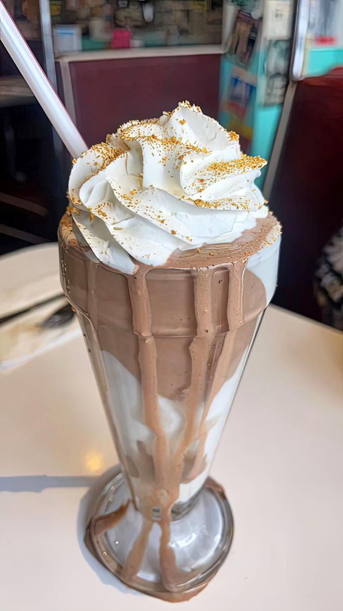 Not all heroes wear capes, but some milkshakes wear crowns. This chocolate creation with its whipped cream tower demands respect—and a bigger straw.