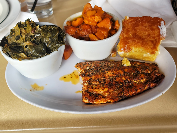 This isn't just a plate—it's a Southern symphony: perfectly seasoned fish, collard greens singing with flavor, and candied yams that could make your grandma jealous.