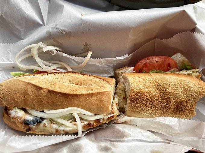 Architecture meets artistry—layers of chicken, cheese, and veggies create a structural masterpiece that somehow fits between two pieces of bread.