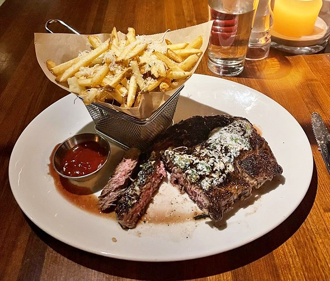A perfectly medium-rare steak with blue cheese crust alongside parmesan fries – proof that sometimes the simplest pleasures are the most profound.