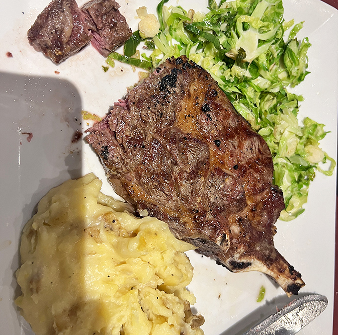 A perfectly seared steak with just the right char marks—nature's artwork on a plate. The mashed potatoes aren't just a side; they're a buttery cloud of comfort.
