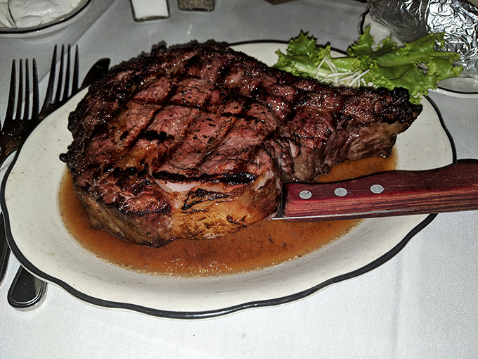 Behold the star of the show! This perfectly grilled steak with its beautiful crosshatch marks sits in a pool of savory jus, practically begging to be devoured.
