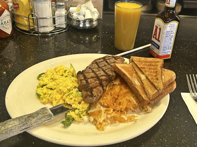 Steak and eggs: civilization's perfect answer to hunger. Golden scrambled eggs, crispy hash browns, and a steak with grill marks that mean business.