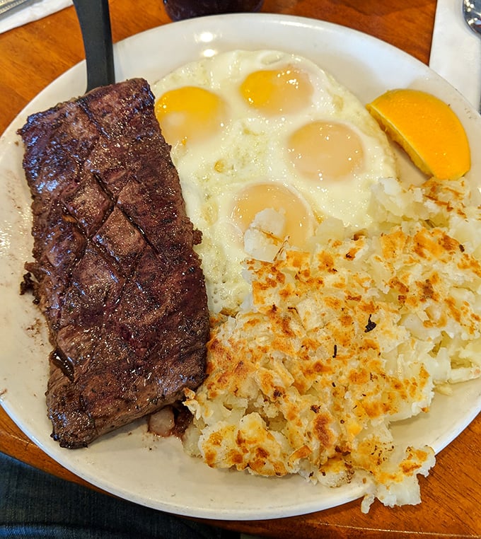 Behold the star attraction: a perfectly seared steak alongside sunny-side-up eggs. Those crispy hash browns aren't playing a supporting role—they're co-stars.