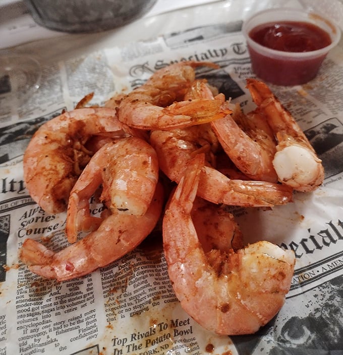 These aren't just steamed shrimp; they're little pink promises of perfection. Served on newspaper because fancy plates would only get in the way.