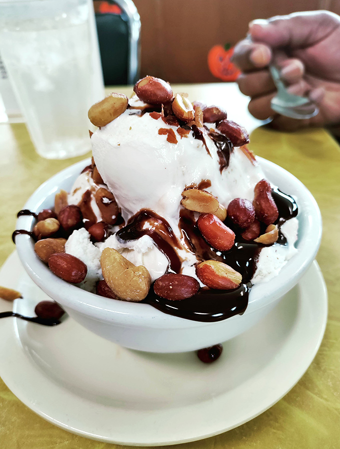 Ice cream architecture at its finest. Vanilla scoops crowned with freshly roasted nuts and chocolate sauce—proof that perfection exists in a bowl.