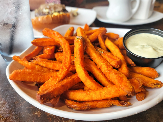 These golden beauties arrive like sunset on a plate, each fry achieving that perfect crispy-fluffy balance we dream about.