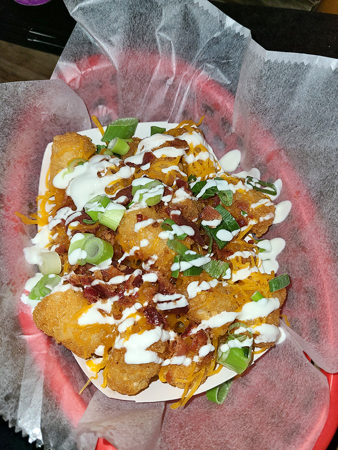 Golden tots transformed into edible art – crispy perfection topped with bacon, cheese, and pure happiness.