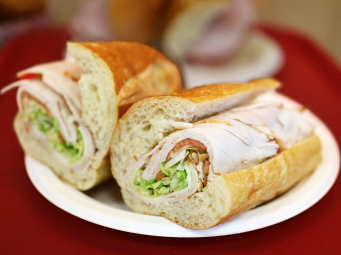 Behold the star attraction: layers of turkey, crisp veggies, and that perfect bread—architecture you can eat without a building permit.
