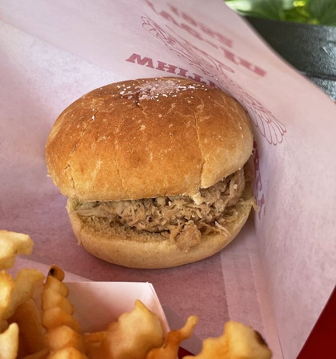 The signature turkey sandwich arrives unassuming yet magnificent. Tender shredded turkey on a pillowy bun—proof that simplicity, when done right, is culinary poetry.