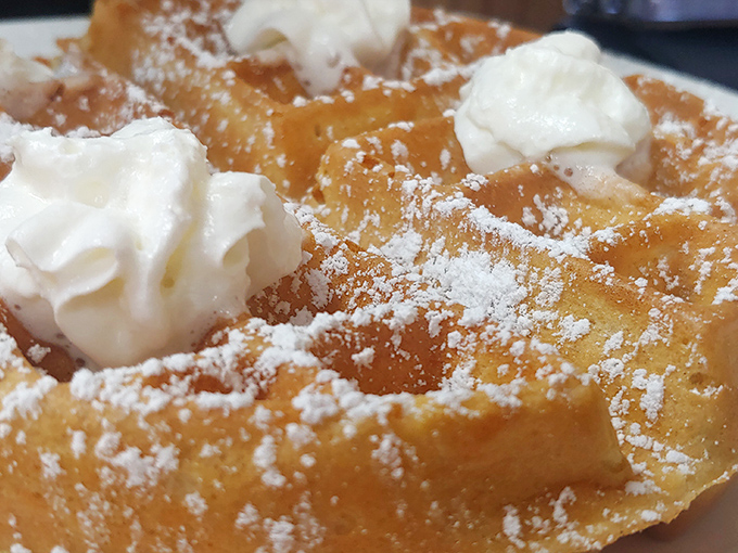 Golden perfection meets pillowy interior. Those dollops of whipped cream aren't just toppings—they're the exclamation points on a breakfast statement.